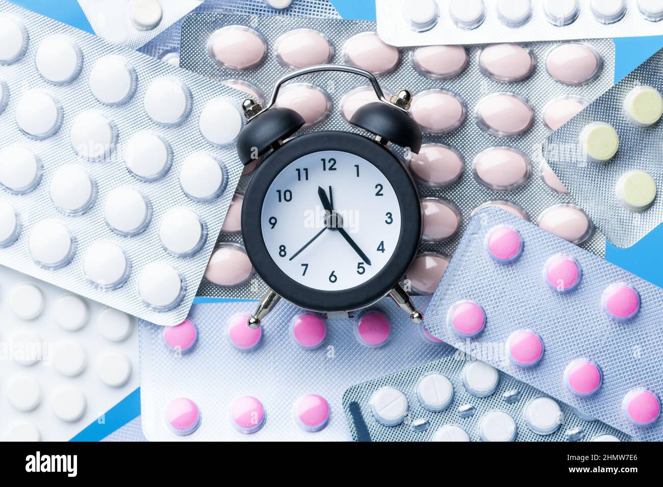 Alarm clock with pills, close up. Medicine and healthcare concept Stock ...