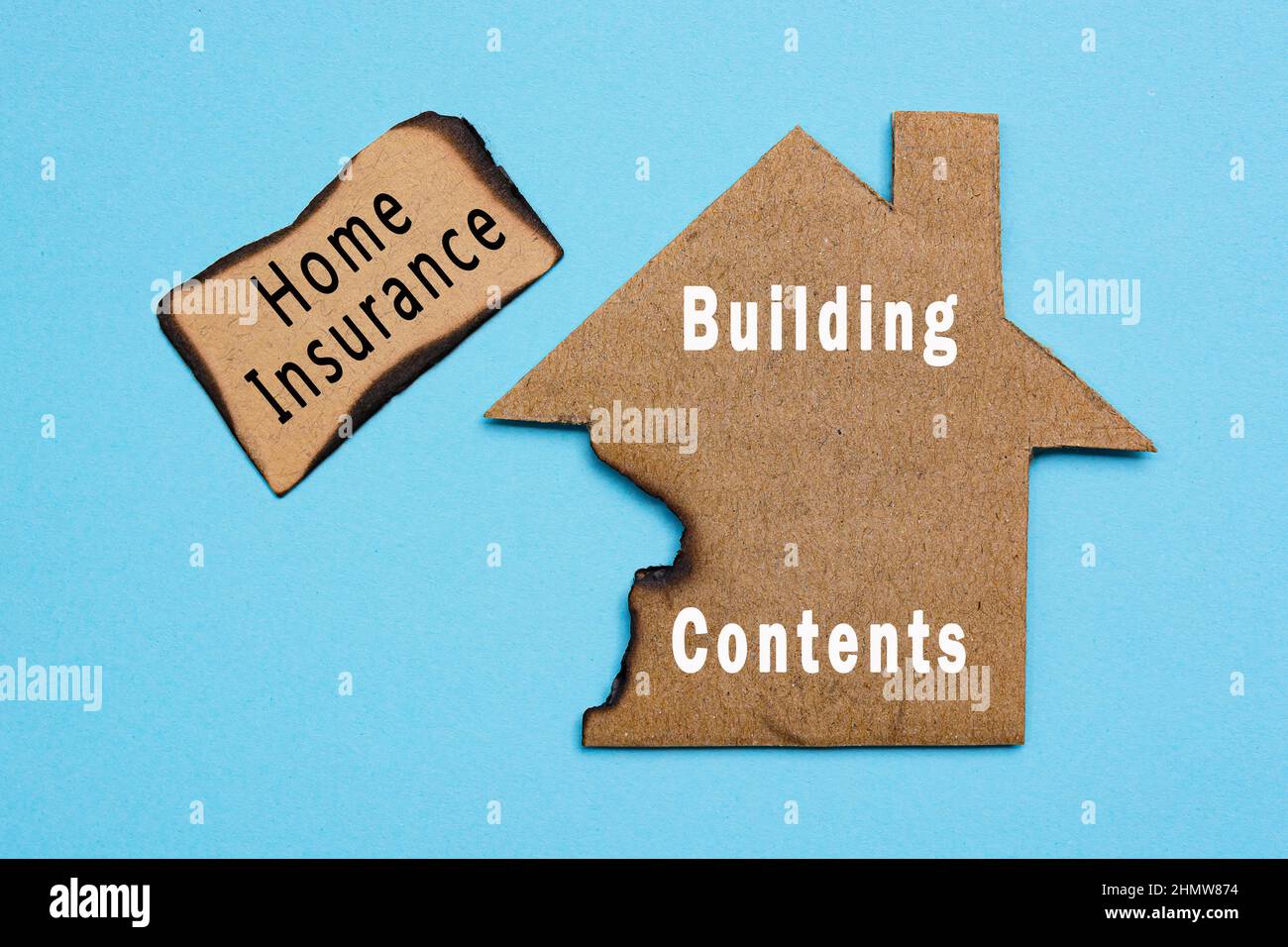 Home insurance, building and contents text on burned paper house model ...