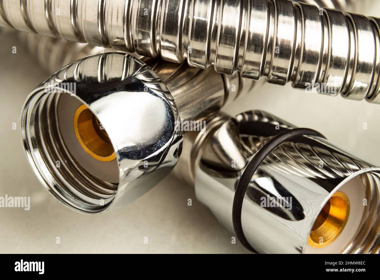 Shower hose. Close-up top view on white marble background. Repair ...