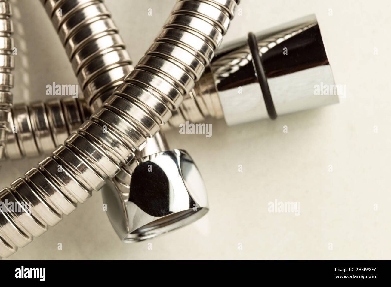 Shower hose. Close-up top view on white marble background. Repair ...