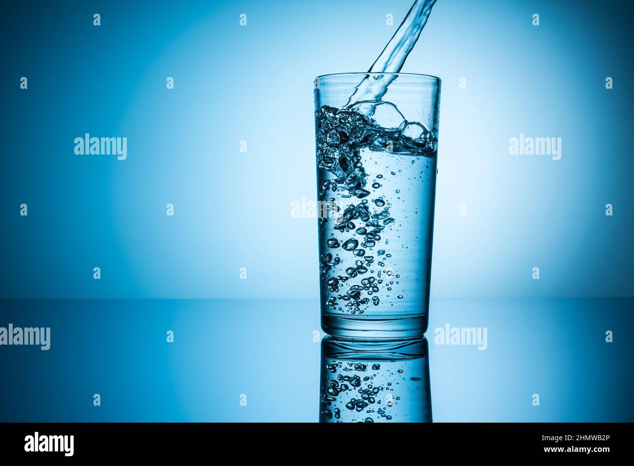 mineral water flows in to glass Stock Photo - Alamy