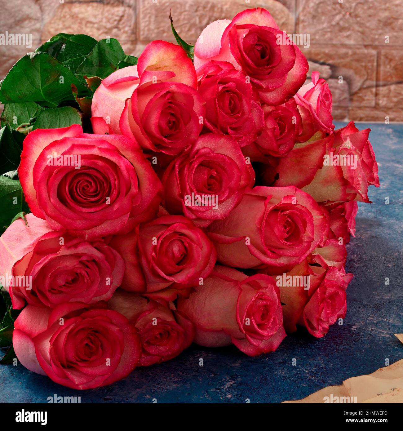 A beautiful bouquet of roses is made against a brick wall and on the ...