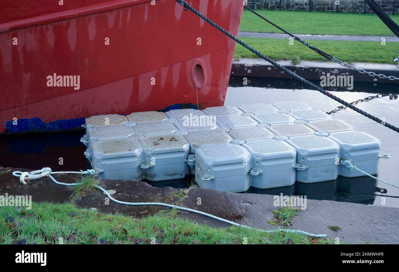 Barge boat with buoy floats along side on canal Stock Photo - Alamy