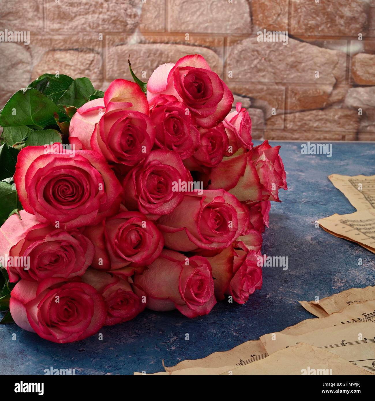 A beautiful bouquet of roses is made against a brick wall and on the ...