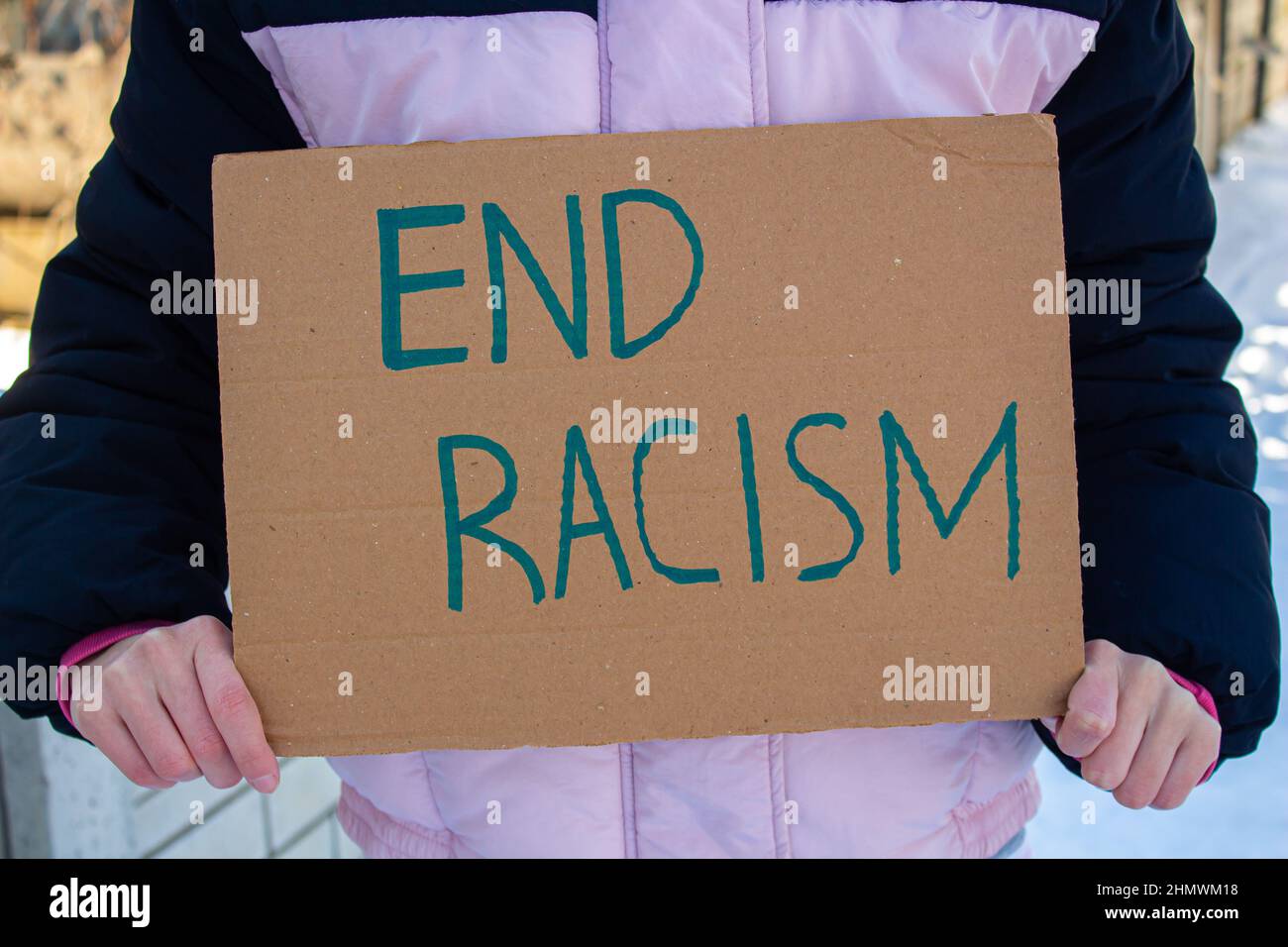 Hand holding cardboard box with end racism text. Woman is protesting ...