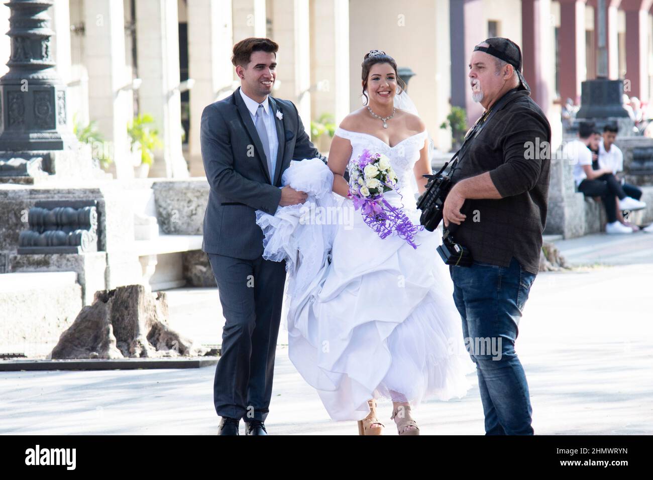 Photographer stands and talks with a young couple at a married ceremony ...