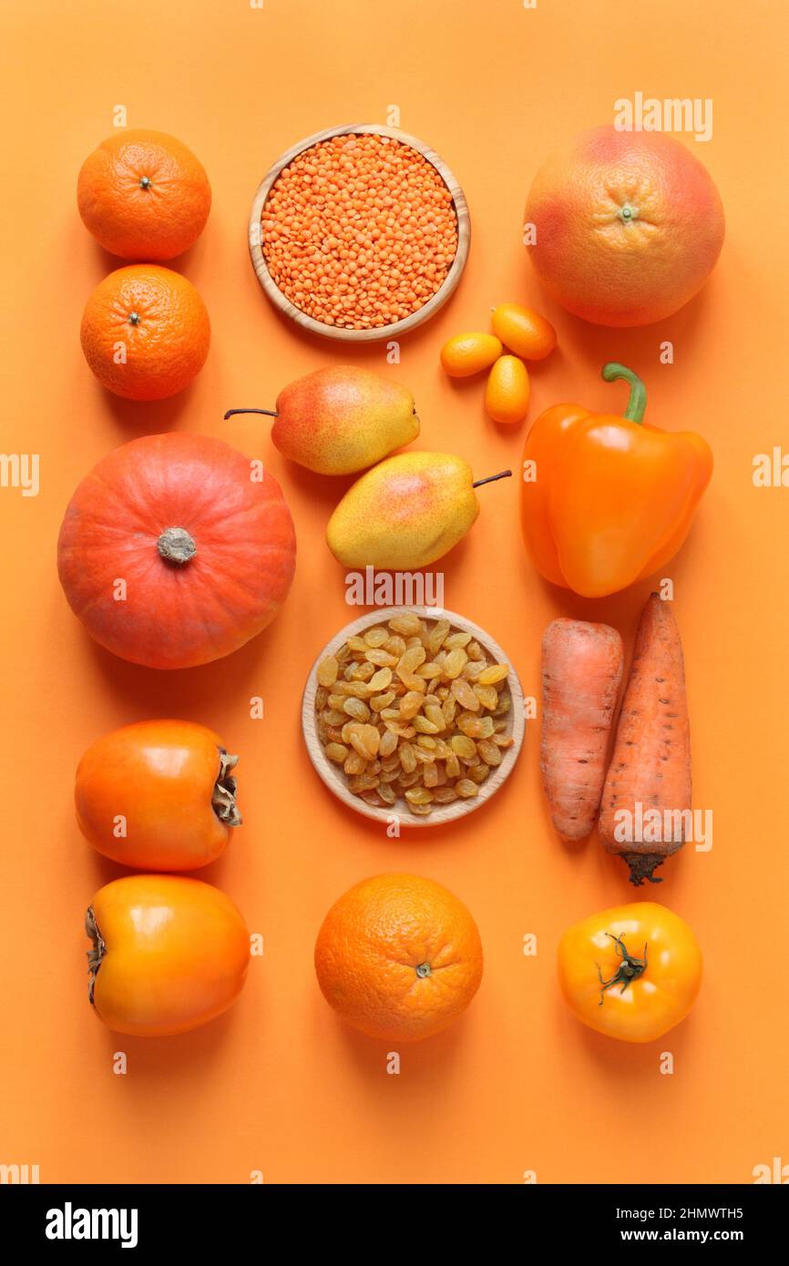 Orange fruits and vegetables on an orange background. Tangerines ...