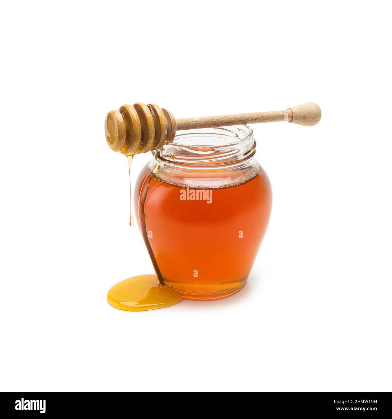 Honey pot with wood stick overflowing Stock Photo - Alamy