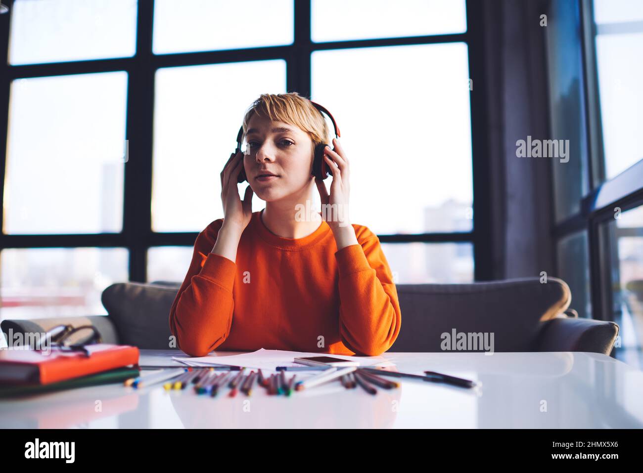 Young designer listening to music working on new project Stock Photo ...