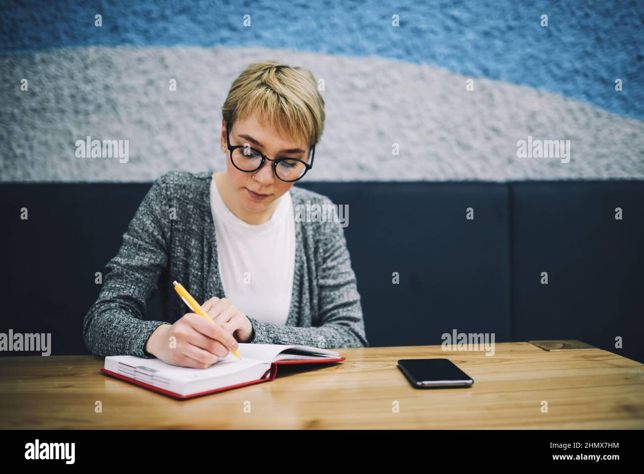 Serious woman writing ideas for project Stock Photo - Alamy