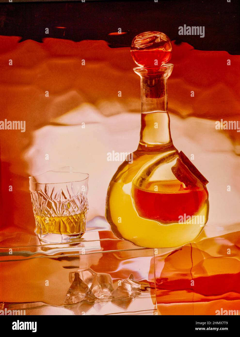 Creative abstract still-life of glass bottle with colour, and a cut ...