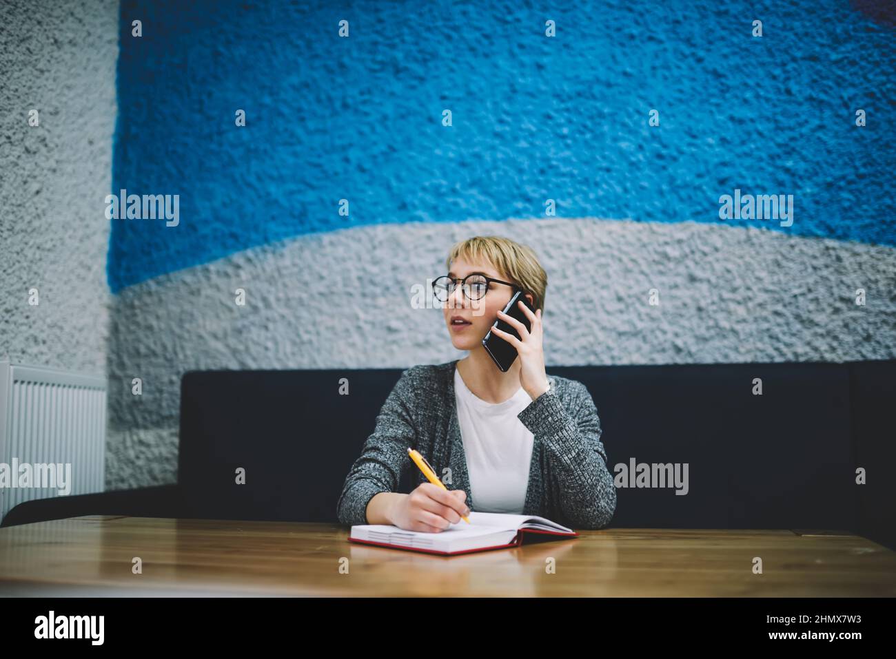 Serious female making phone call during work Stock Photo - Alamy