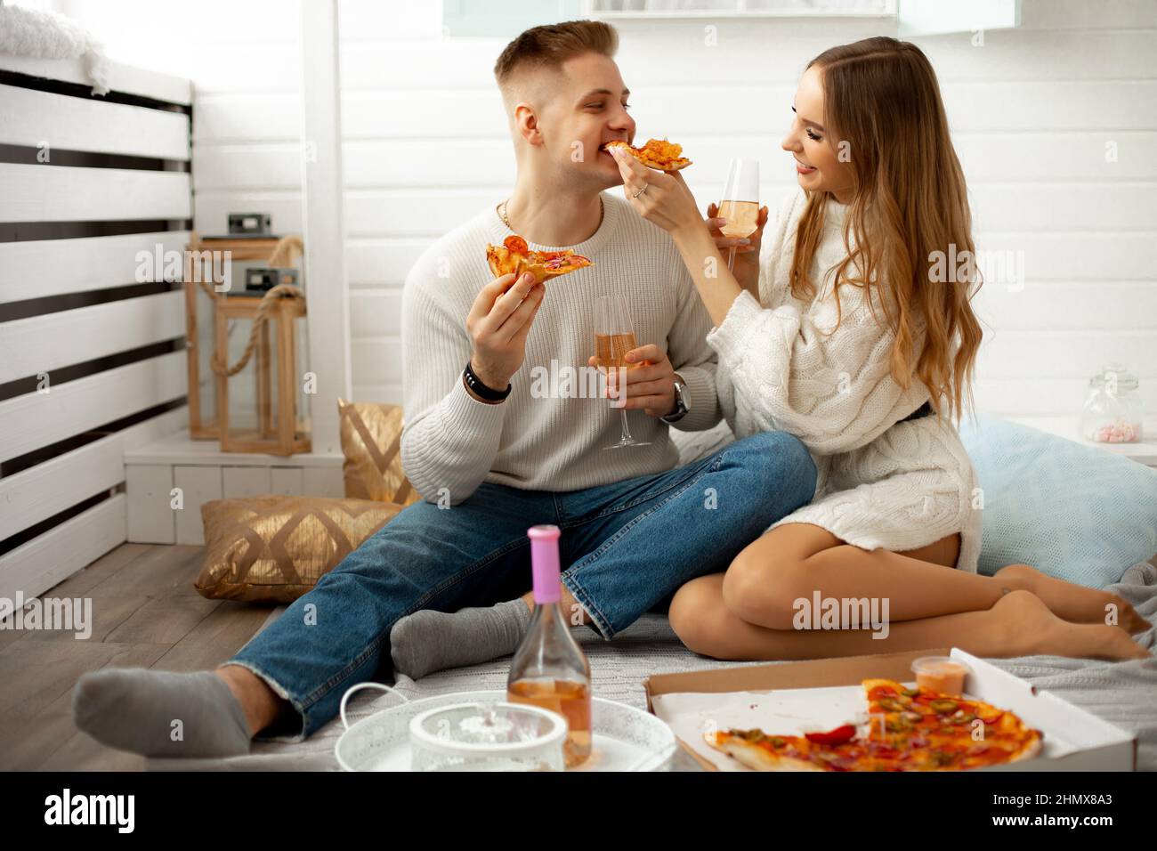 Cute young couple enjoys having lunch together , they jokingly feed ...