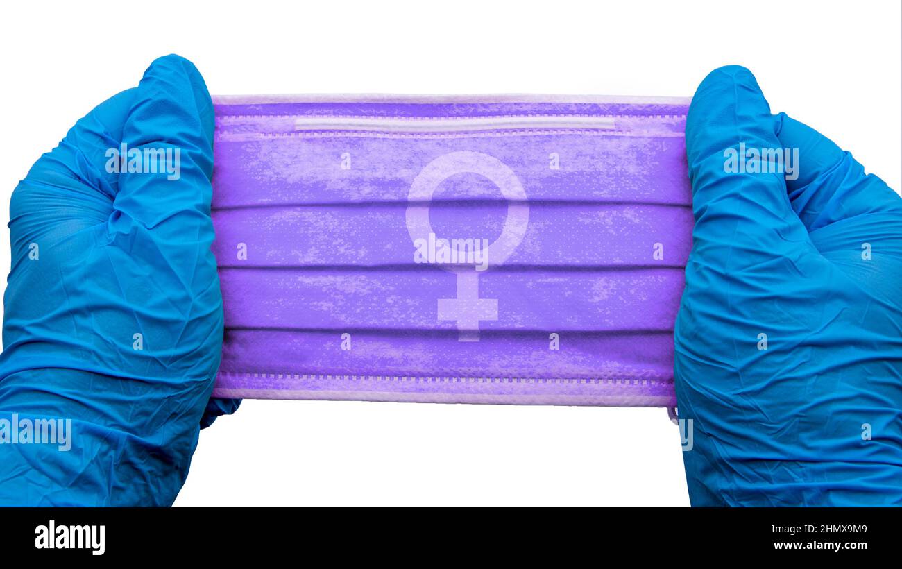 Blue gloves holding a purple medical mask with a woman gender sign on a ...