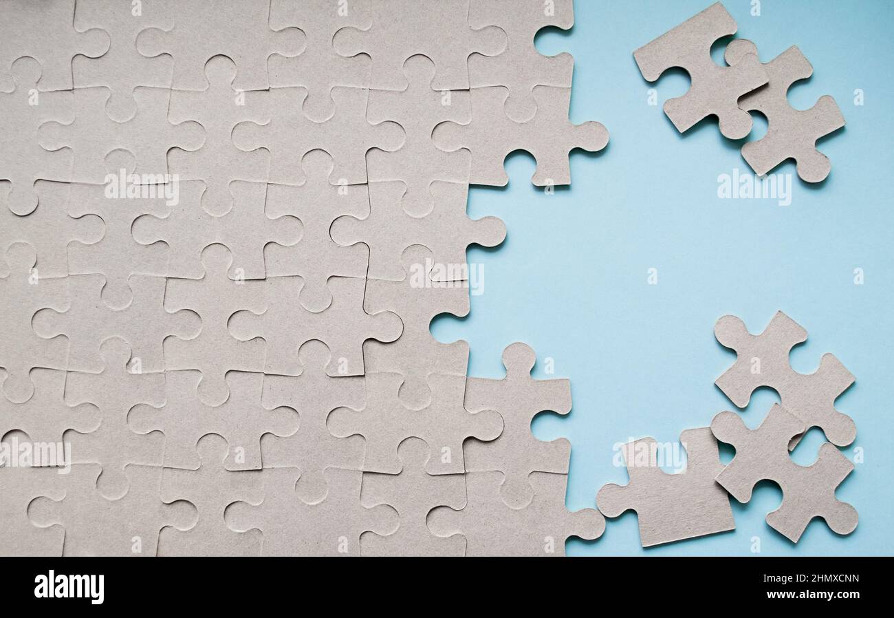 Unfinished cardboard puzzle without drawing. A blue background on the ...