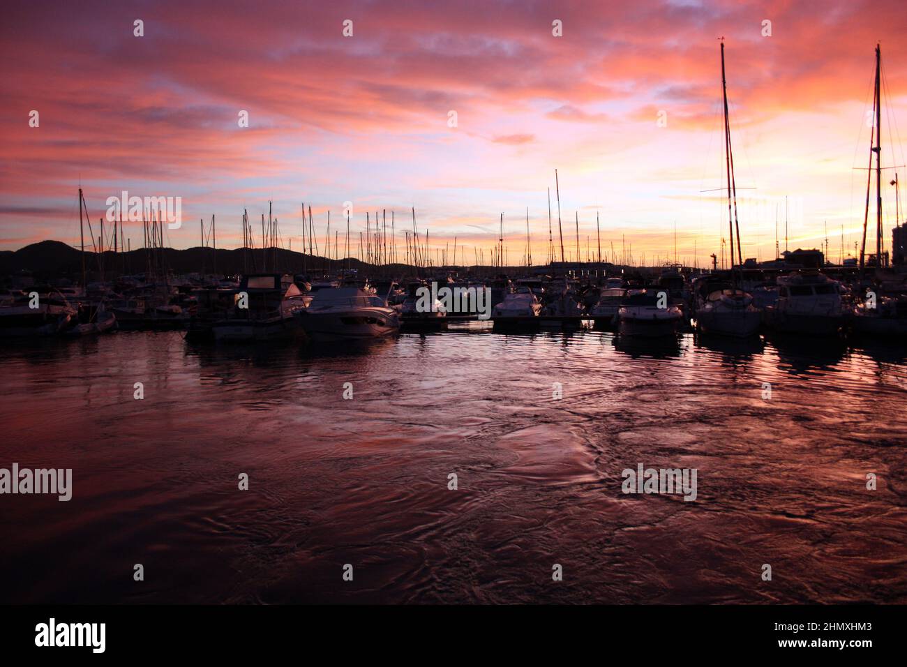 fiery red and purple sunset on ibiza coast view from port at balearic ...