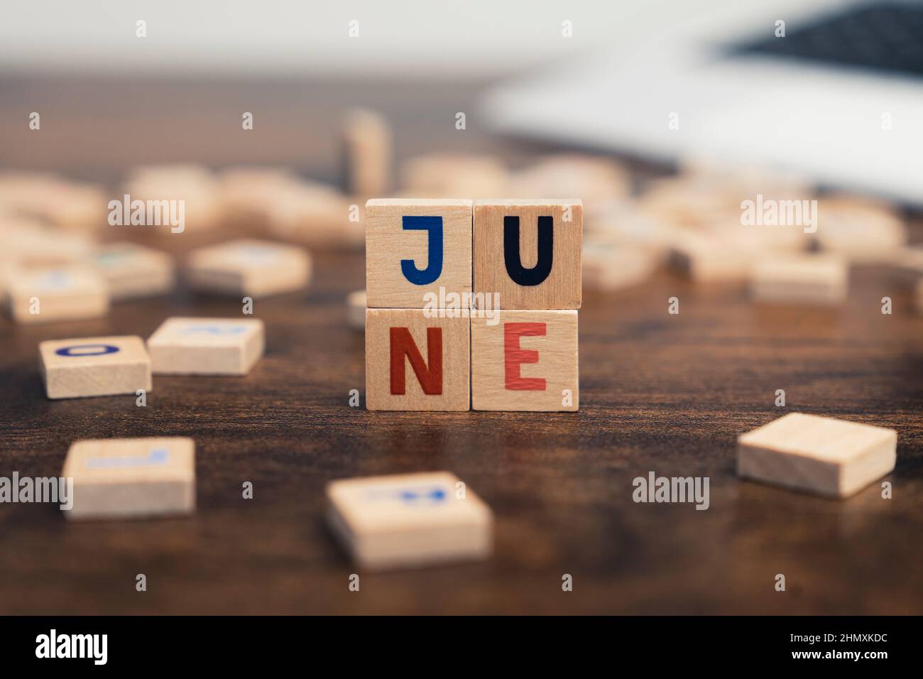 The name of the month June written on wooden cubes od the tabletop of ...