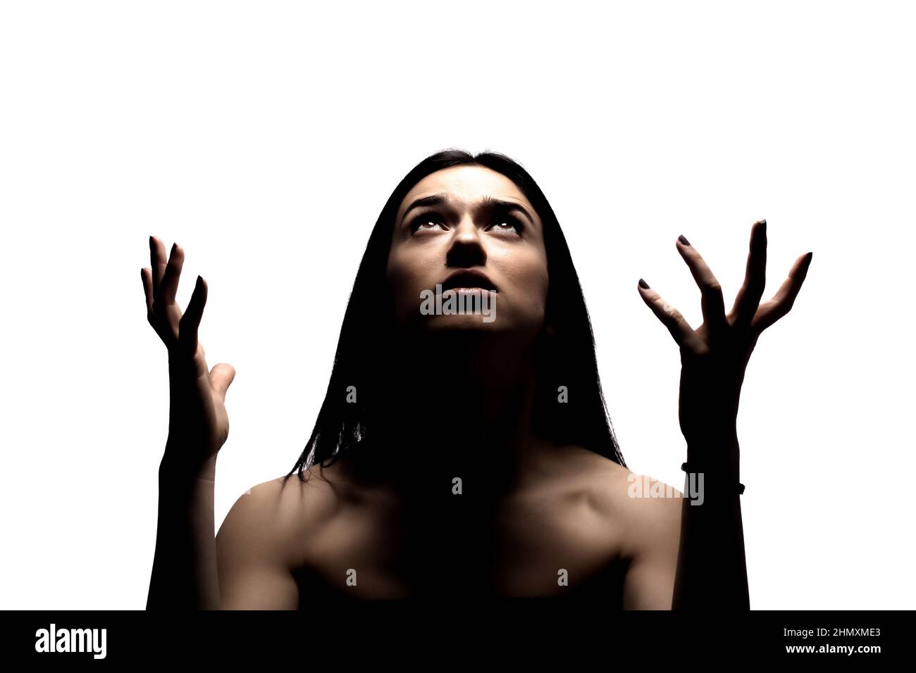 Dark half silhouette portrait with shadows of an angry girl looking up ...