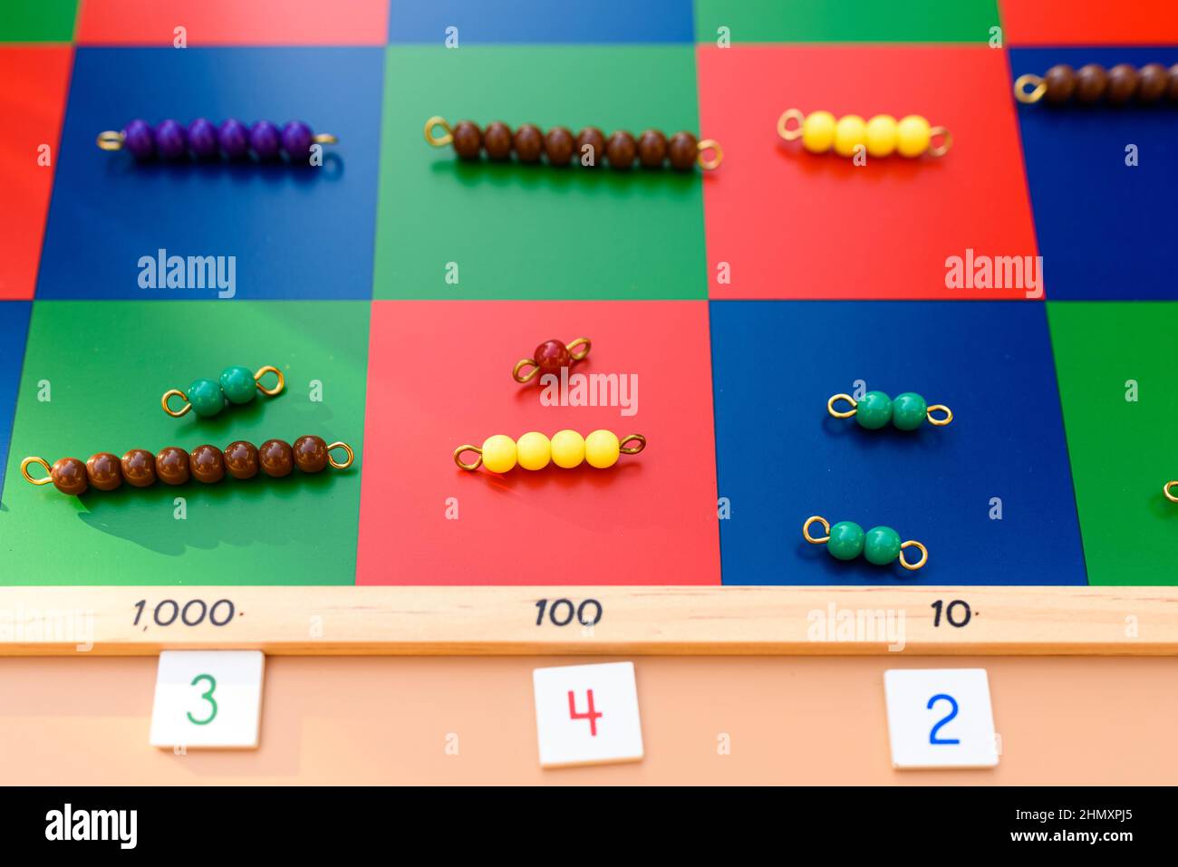 Detail of montessori material, a checker board with tiles and beads ...