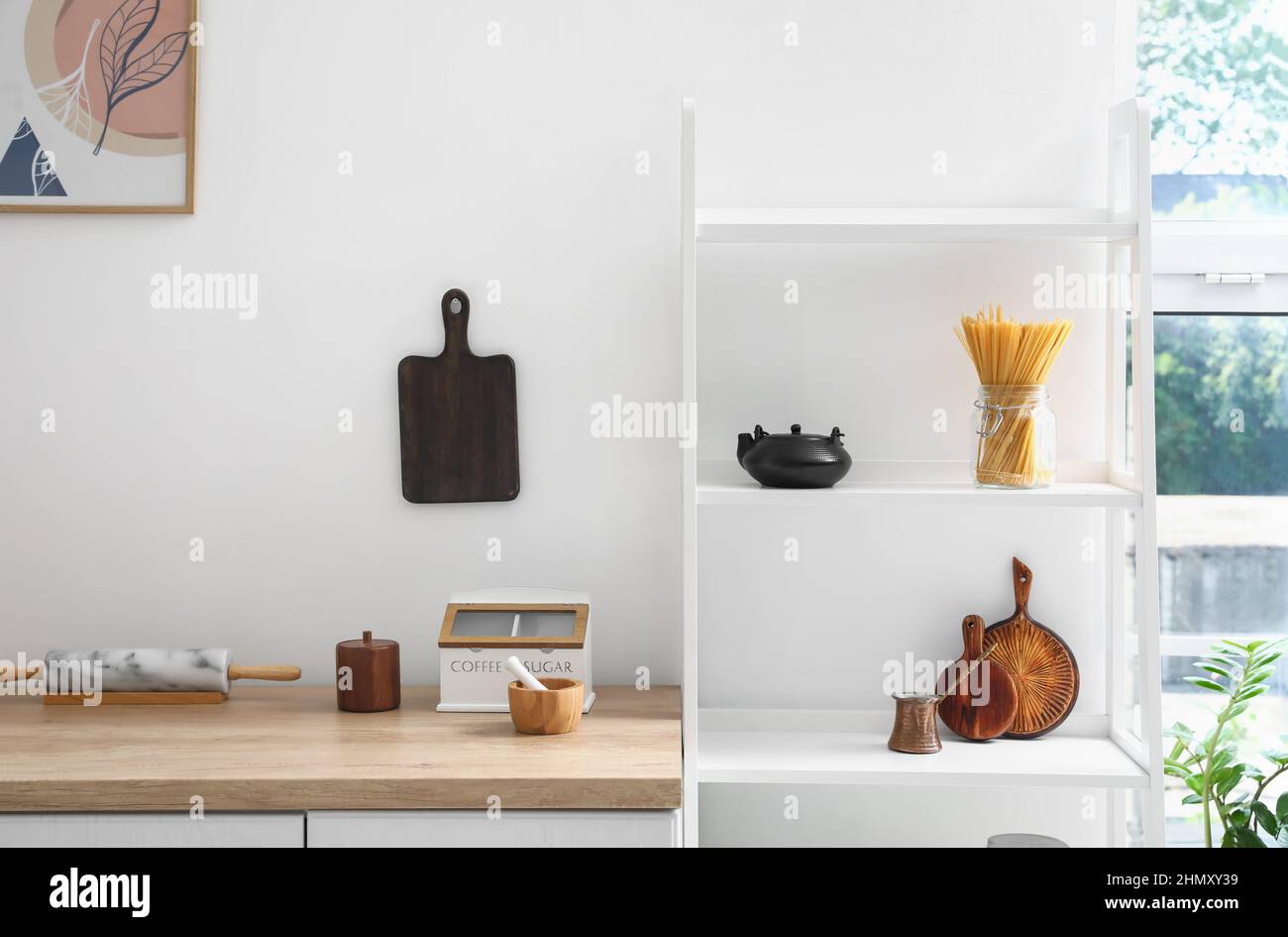 Counter and shelf unit with kitchenware near white wall Stock Photo - Alamy