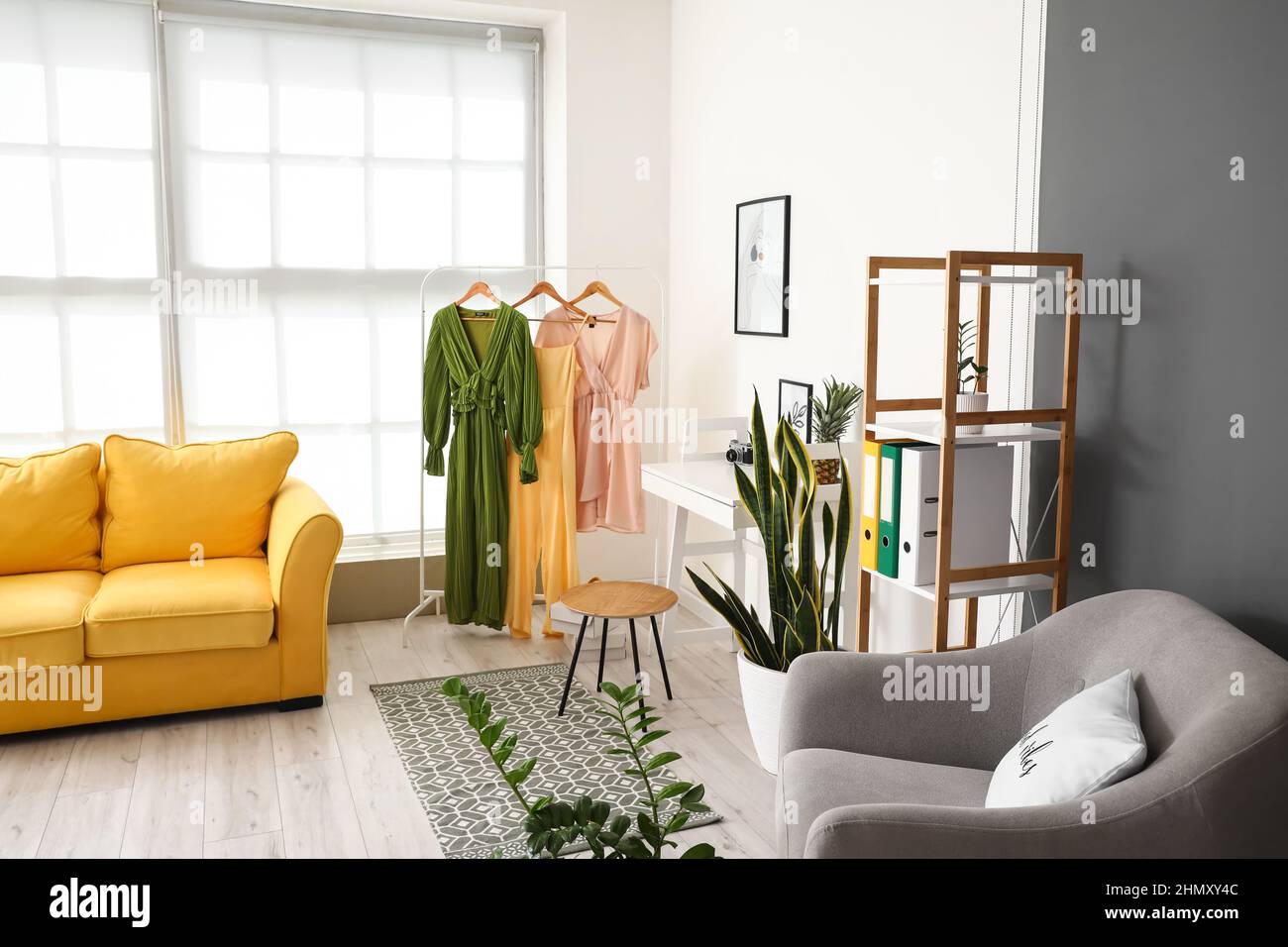 Interior of light room with shelf unit and rack with dresses Stock ...