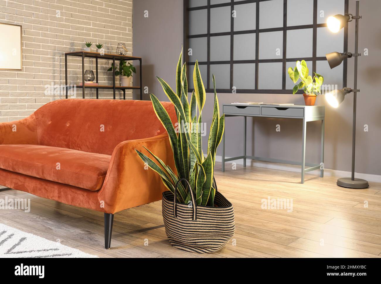 Interior of stylish living room with red sofa, table and glowing lamp ...