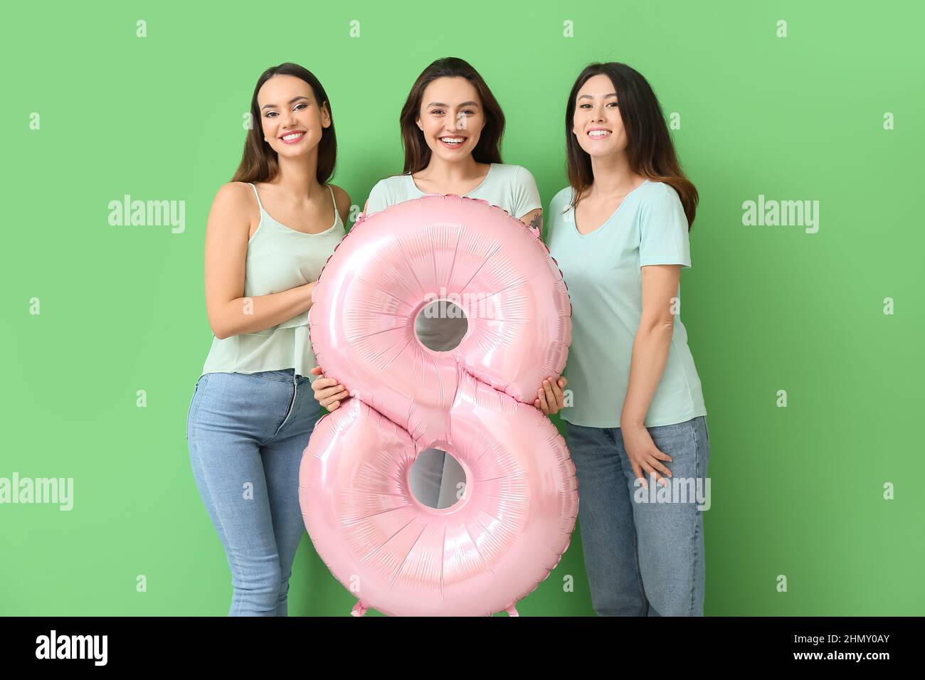 Beautiful women with balloon in shape of figure 8 on green background ...