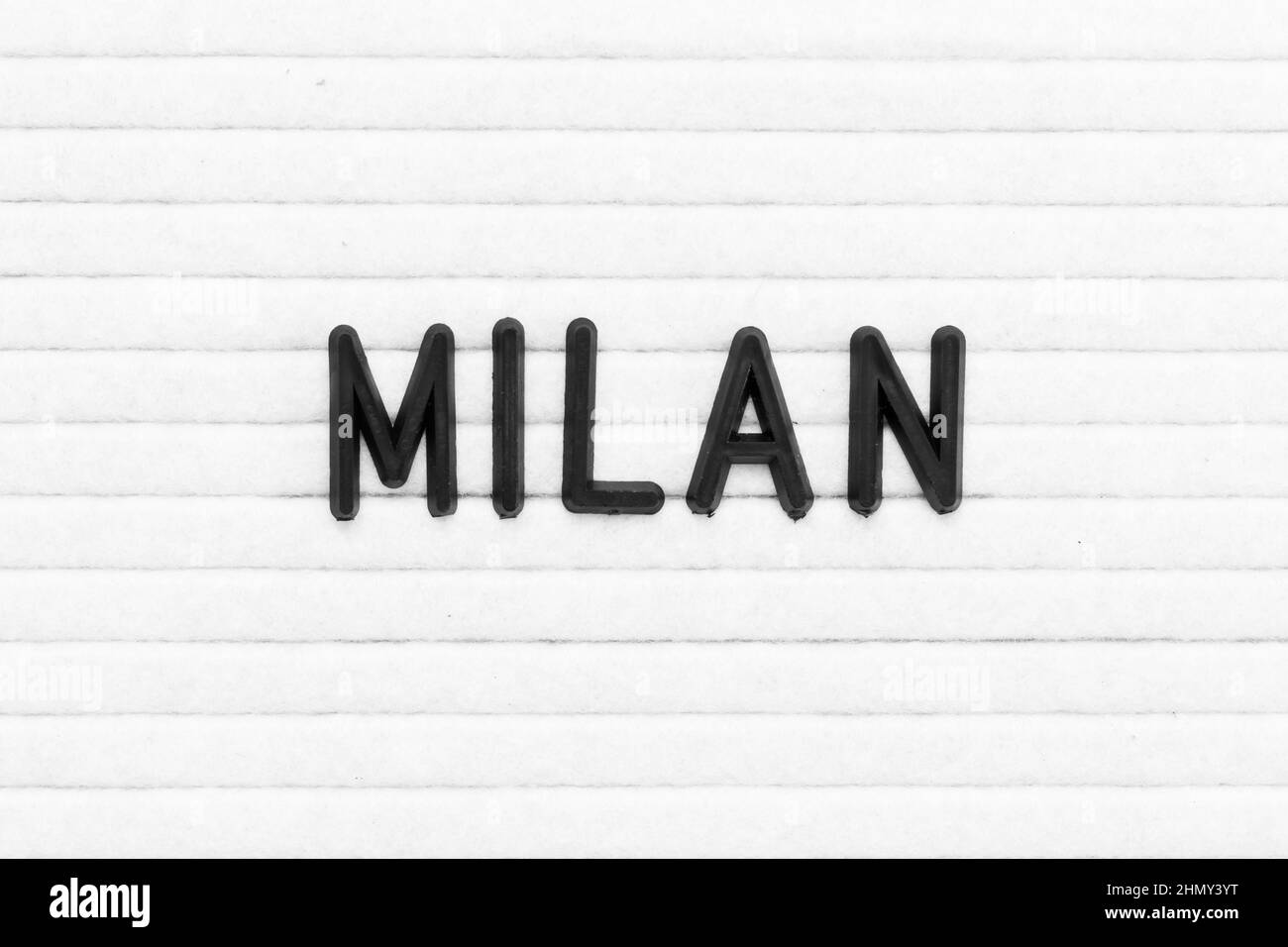 Black color letter in word milan on white felt board background Stock ...