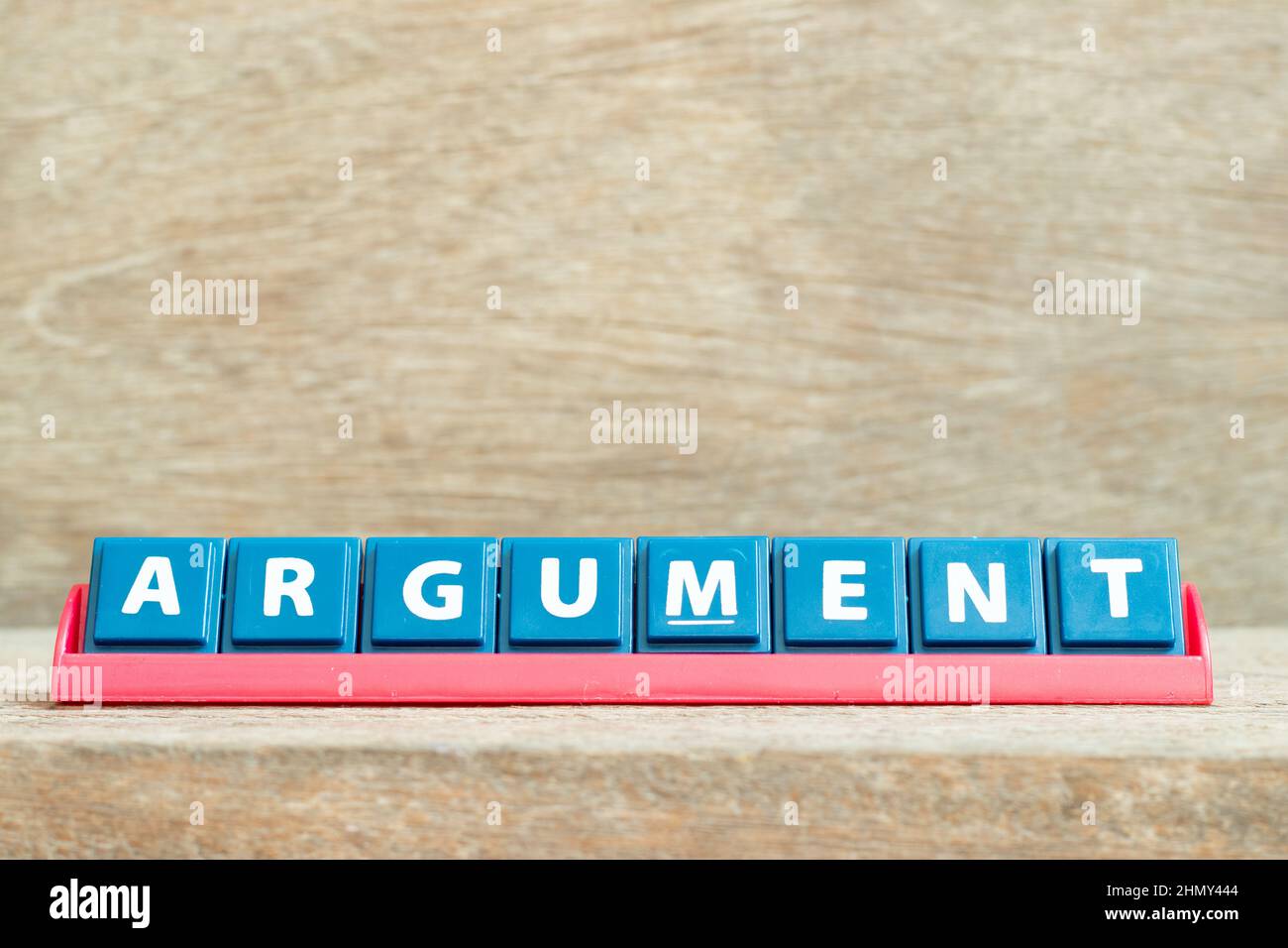 Tile alphabet letter with word argument in red color rack on wood ...