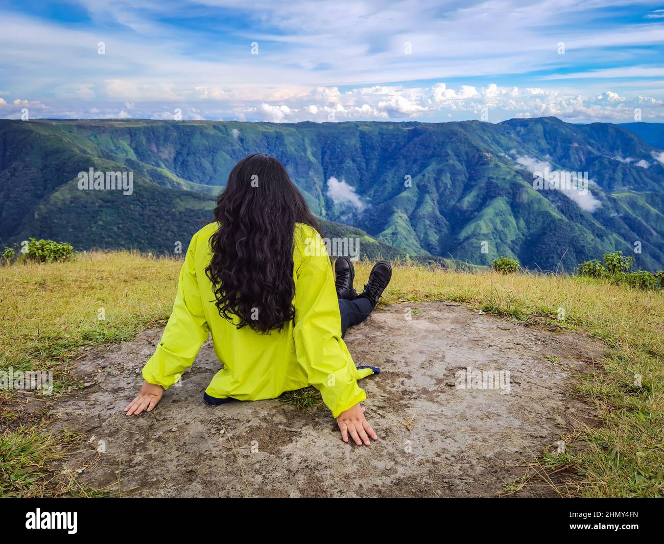 young girl sitting on mountain top with bight blue sky at morning Stock ...