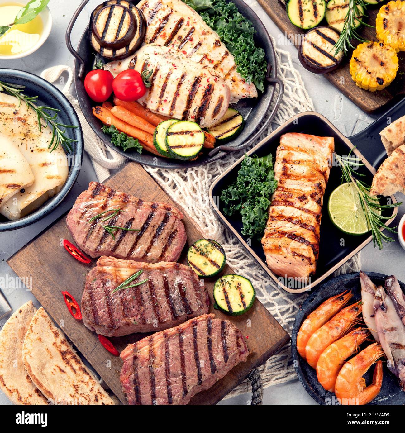 Grilled fish, seafood and meat assortment on light background. Homemade ...