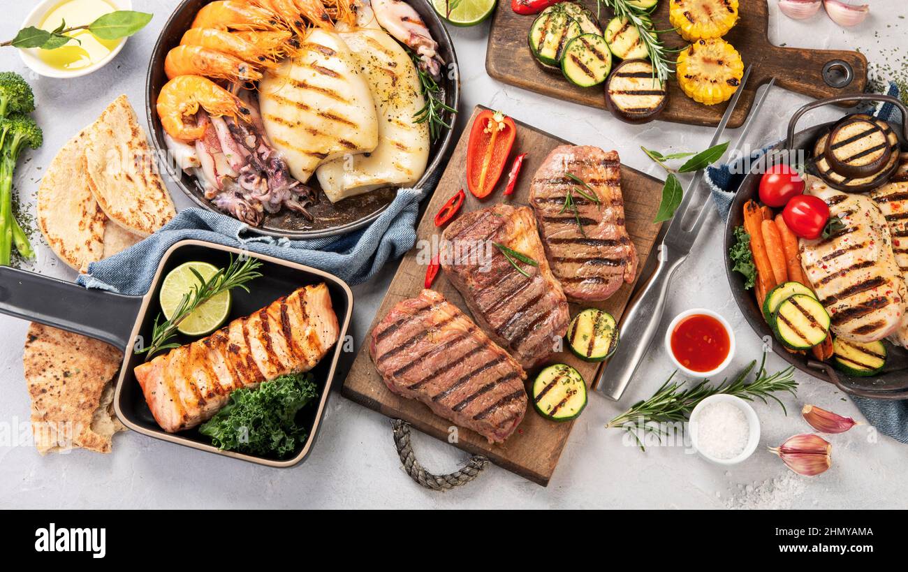 Grilled fish, seafood and meat assortment on light background. Homemade ...
