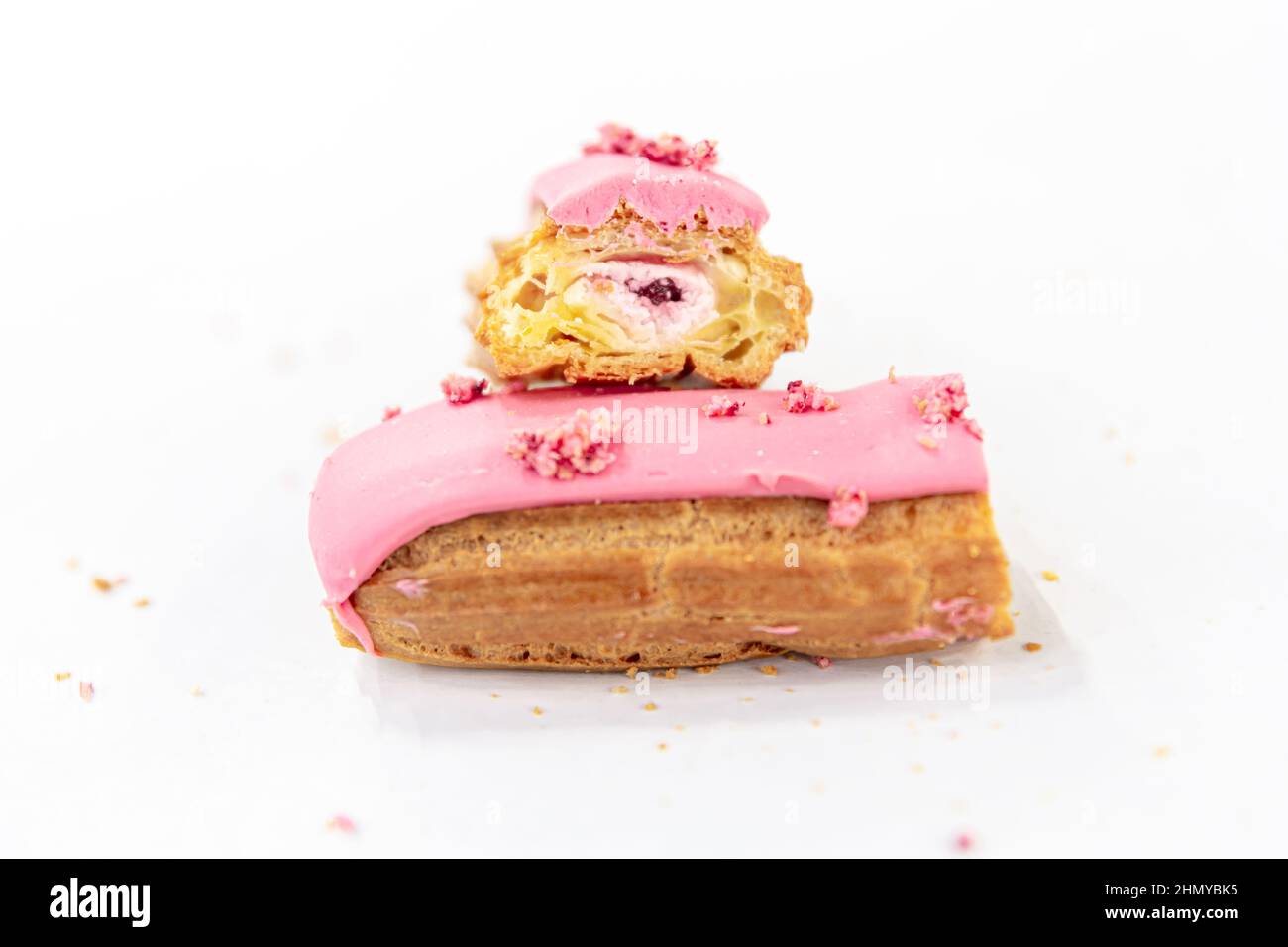 Eclair in pink glaze on a white background isolated Stock Photo - Alamy