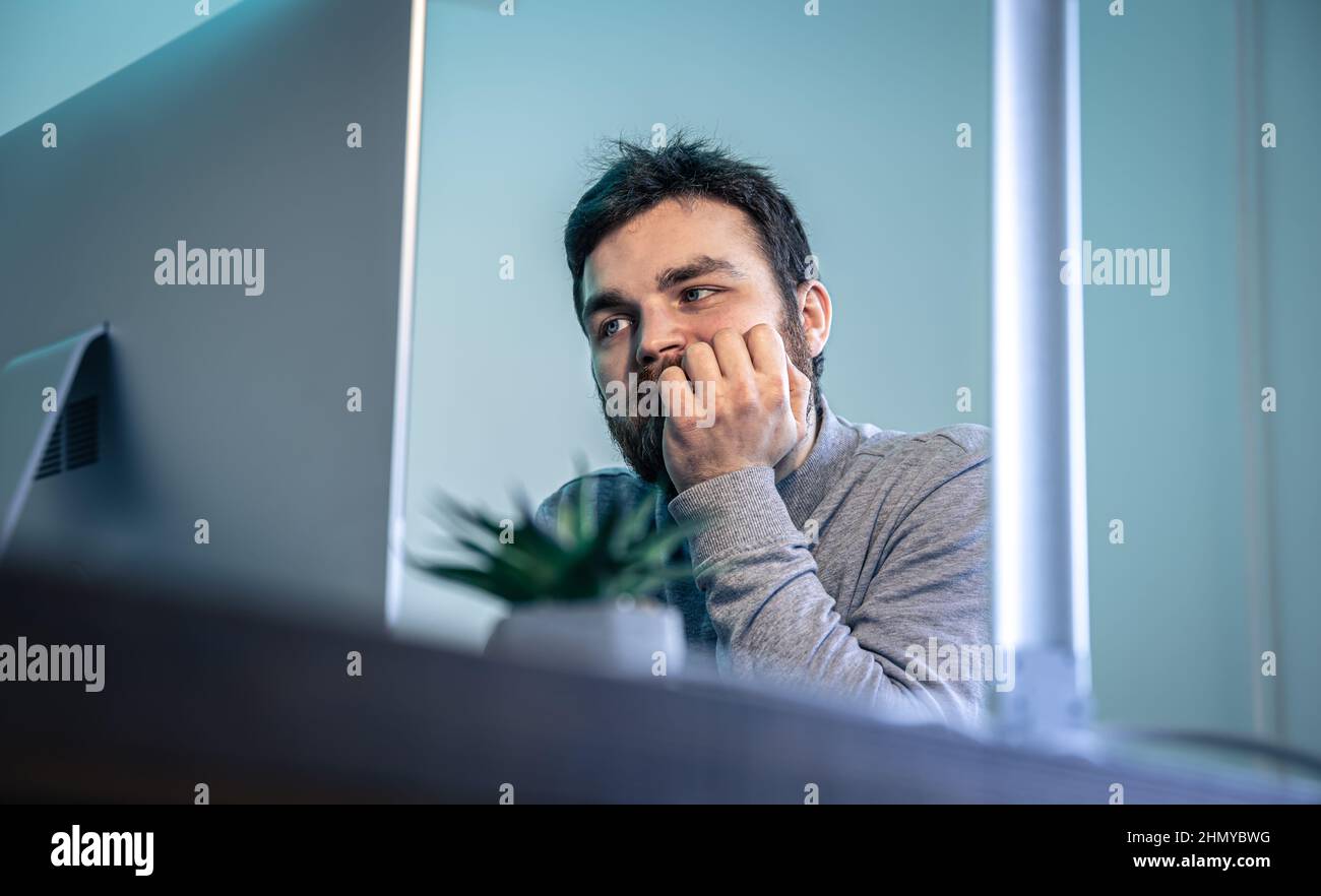 Tired bearded man looks at the computer screen Stock Photo - Alamy
