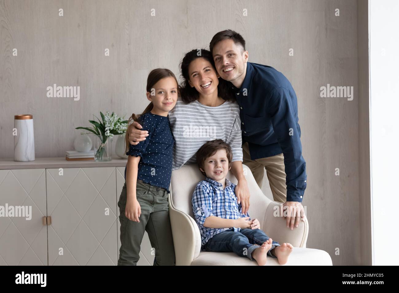 Happy parents, pre teen kid and toddler standing together Stock Photo ...