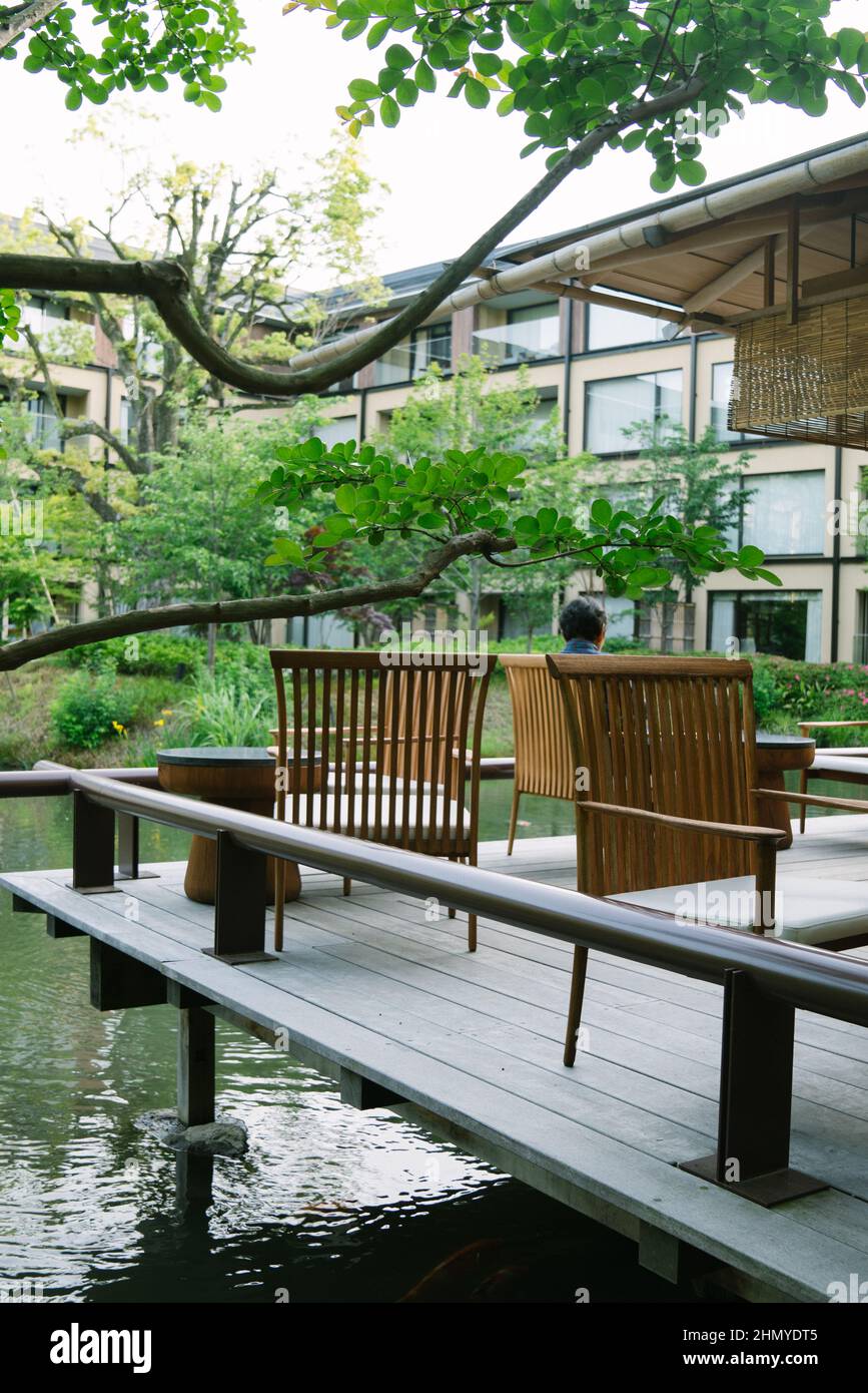 Vertical shot of an outdoor cafe surrounded by greenery and water in ...