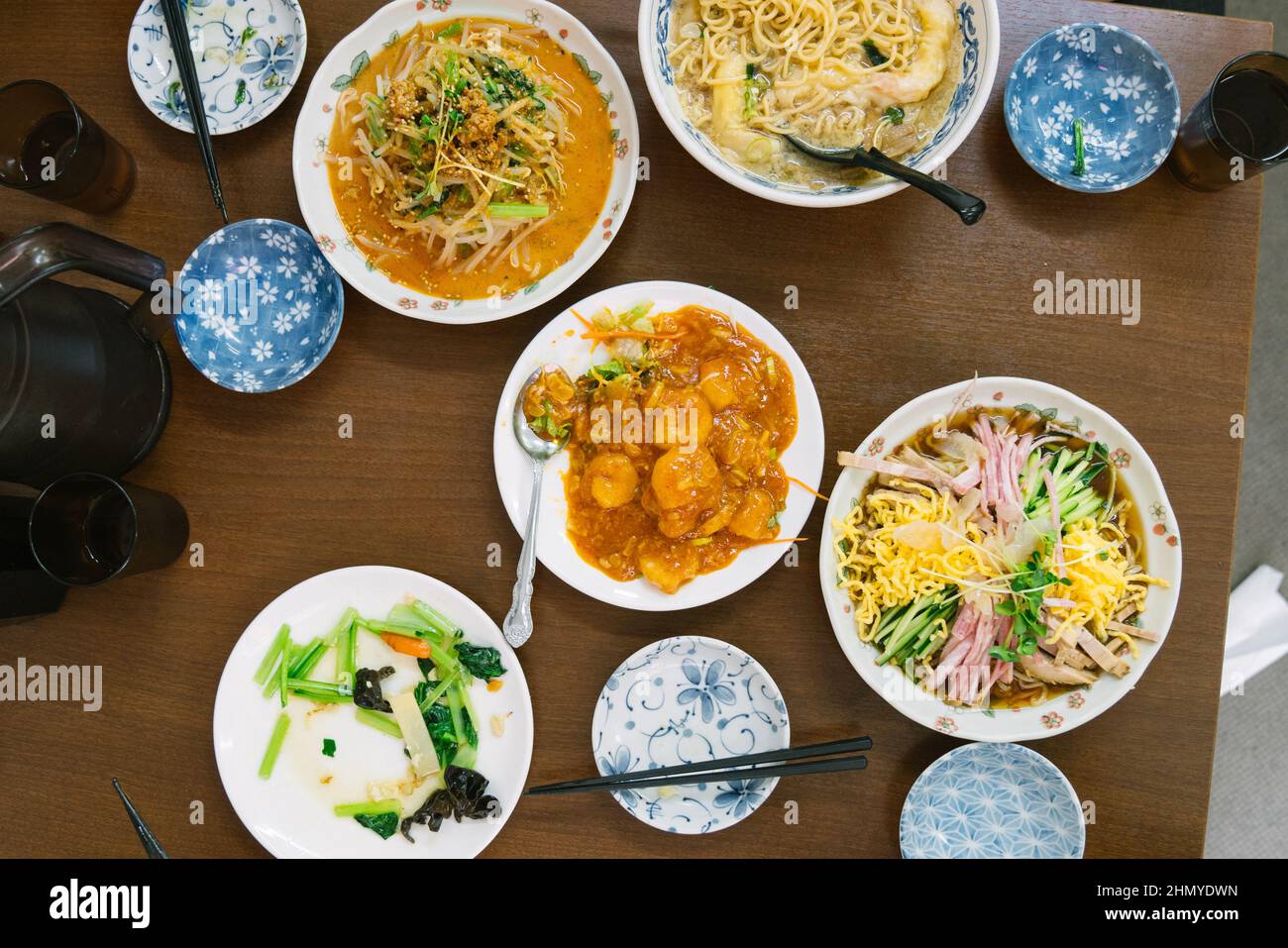 Top view of ramen and different appetizers in bowls on the table in a ...