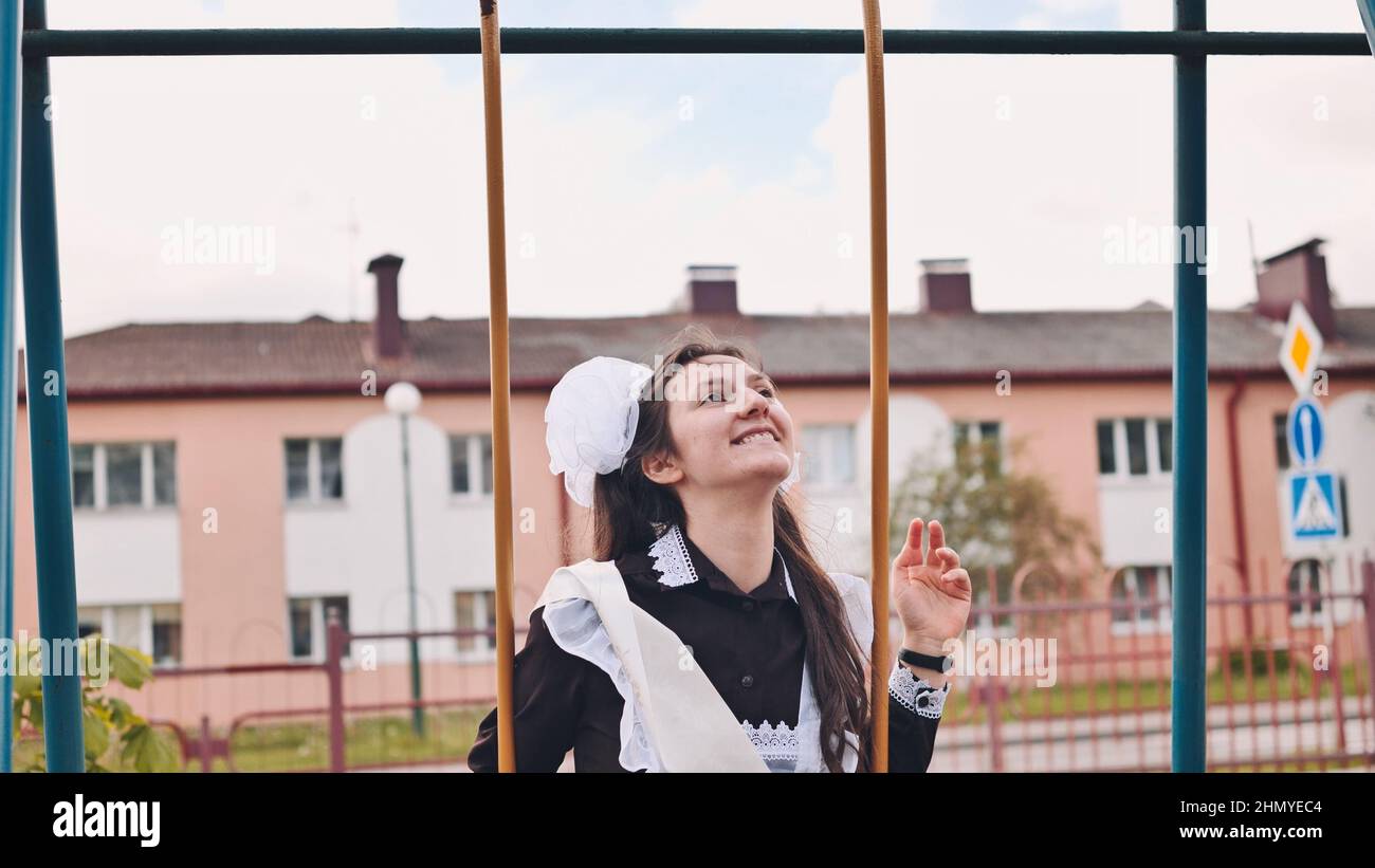 Happy female graduate goes for a swing on the last day of school Stock ...