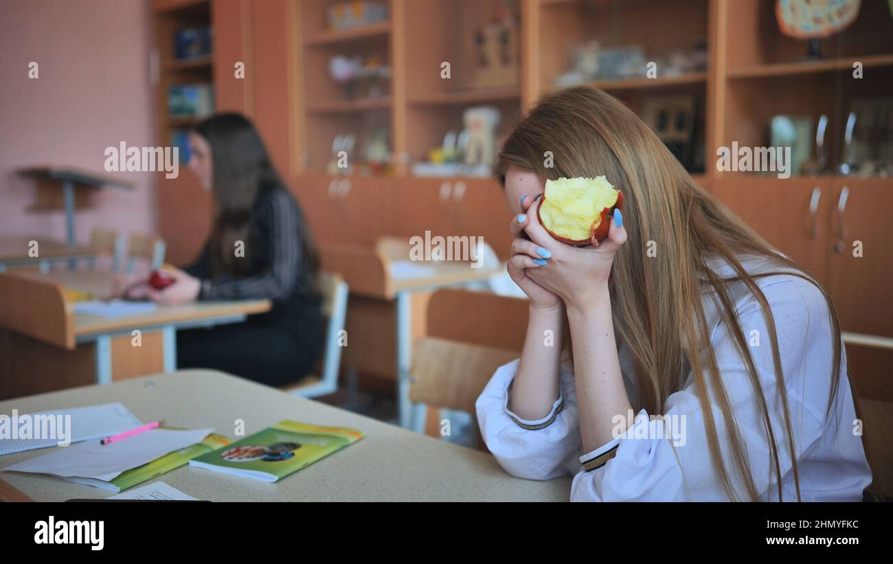 Schoolgirl eat apple in class during recess Stock Photo - Alamy