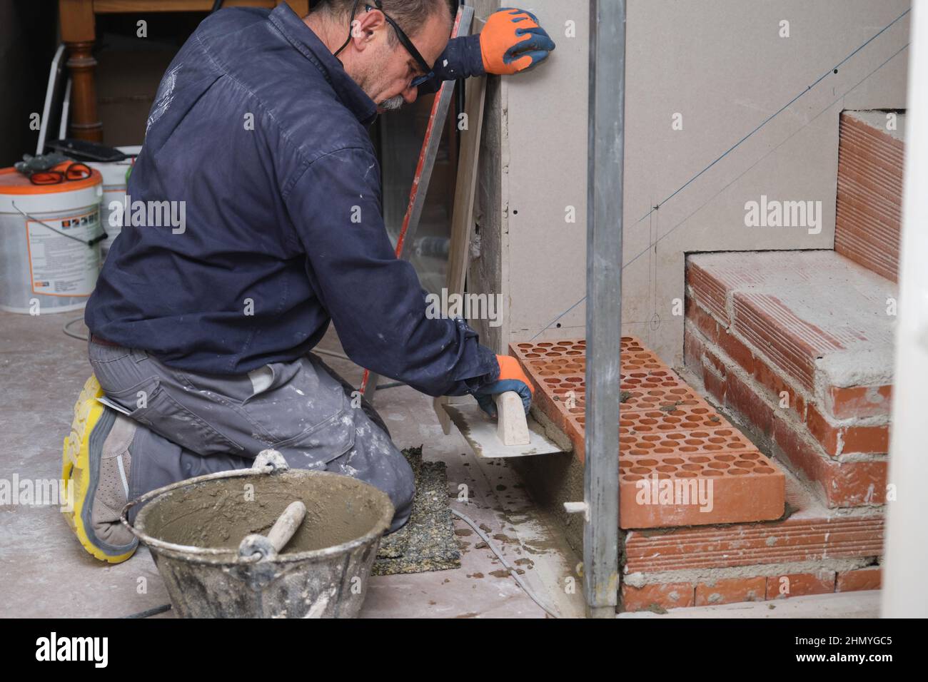 Bricklayer building a brick staircase in a home interior Stock Photo ...