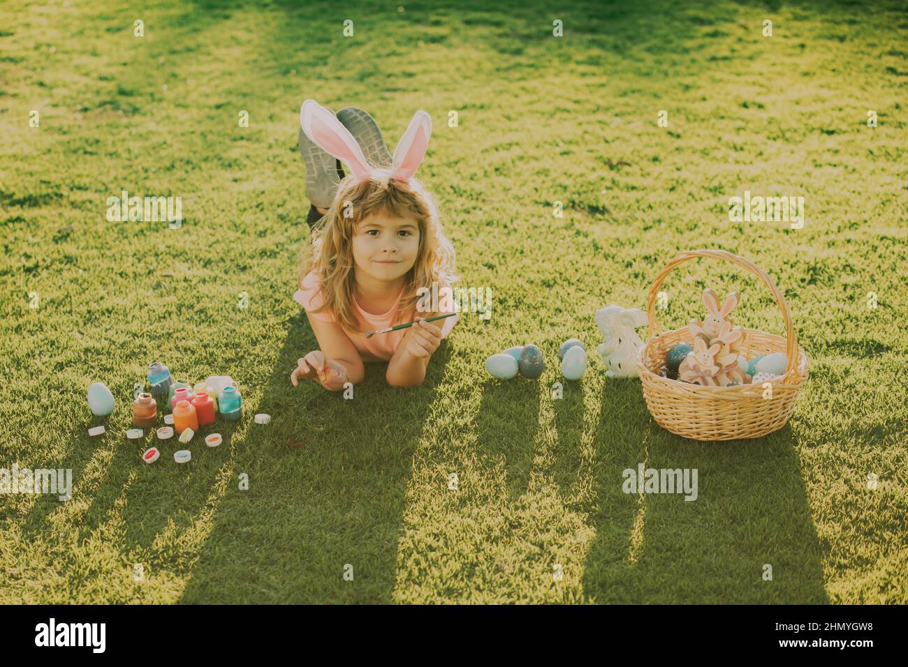 Easter kids boy in bunny ears hunting easter eggs outdoor. Cute child ...