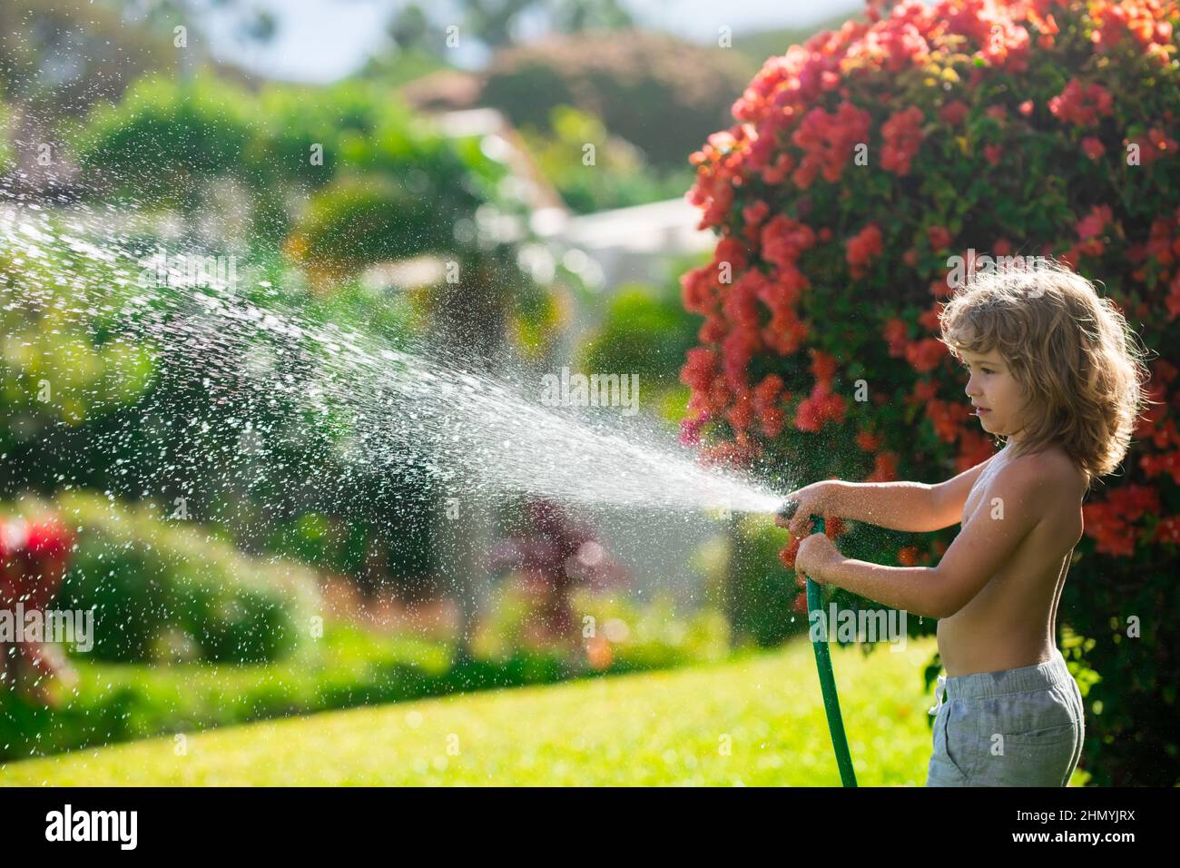 Kids play with water garden hose in yard. Outdoor children summer fun ...