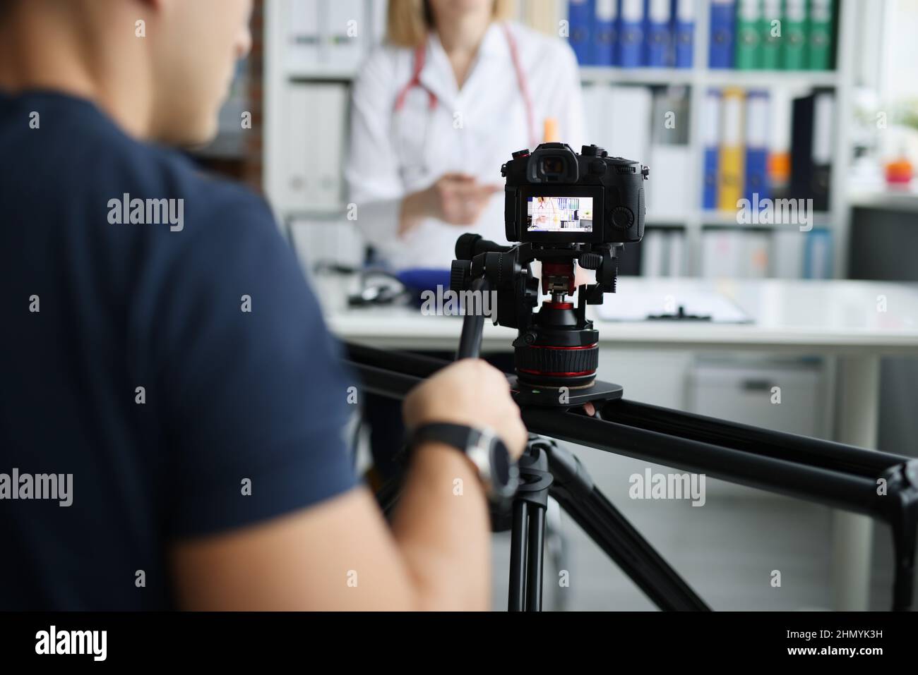 Photographer filming doctor on camera using tripod and slider closeup ...