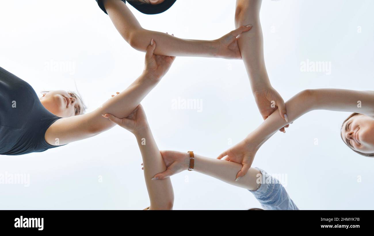 Friends join their wrists and make a circle. Strong friendship concept ...
