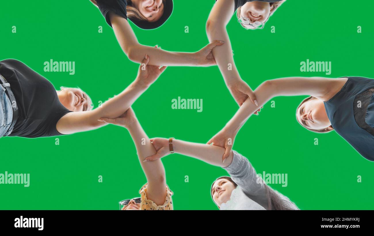 Friends join their wrists and make a circle on a green background ...