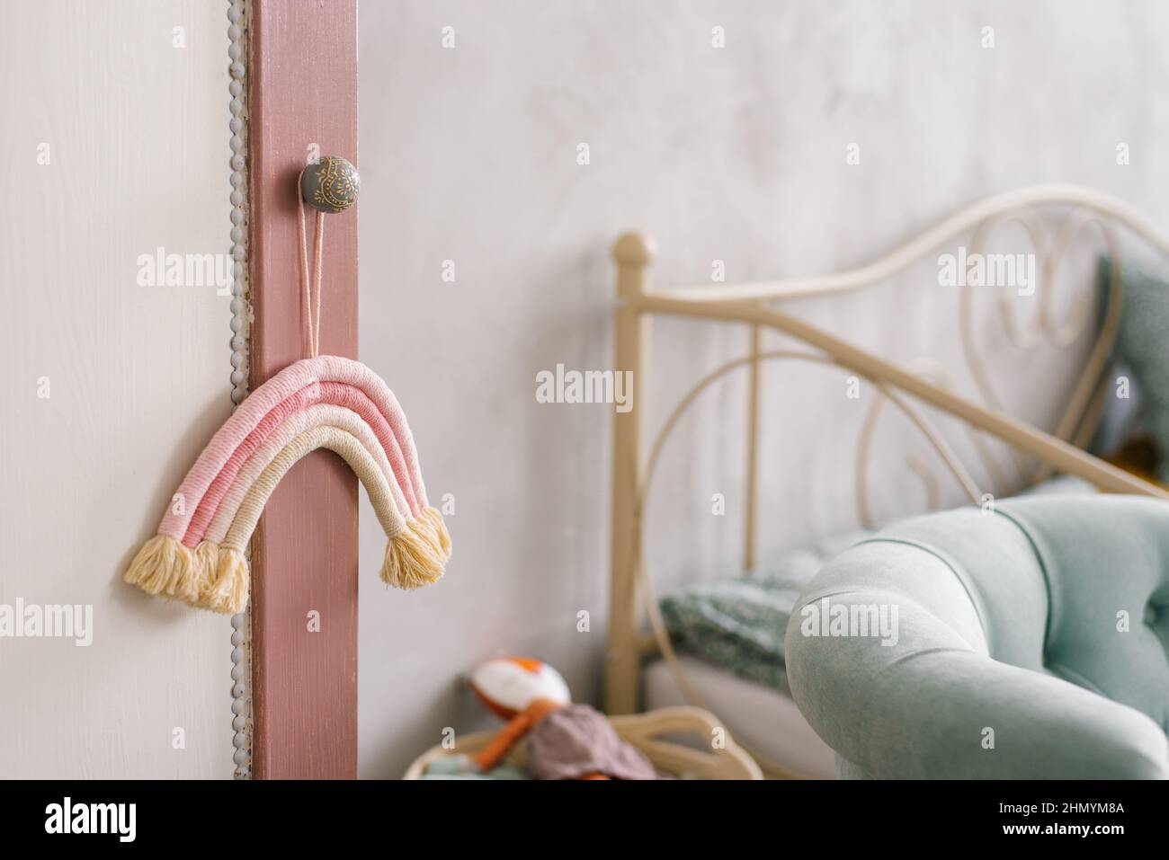 Rainbow thread hanging toy hanging on the handle of the wardrobe in the ...