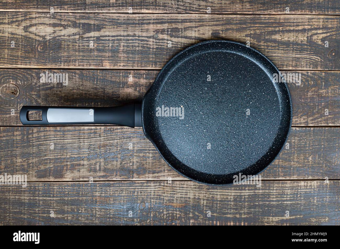 Empty black pancake pan with handled on a rustic wooden background ...