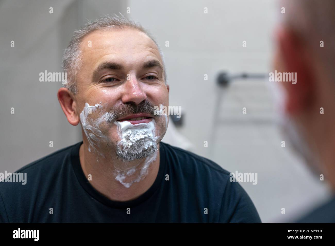 Middle aged handsome man shaving his beard in bathroom Stock Photo - Alamy