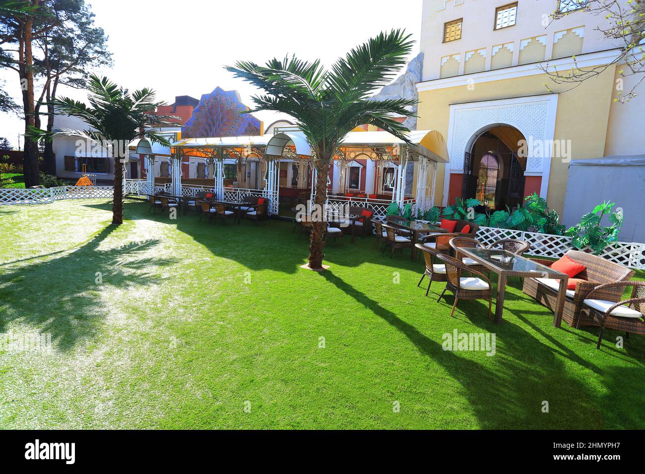 Outdoor alley restaurant with palm trees and tables in the sun Stock ...