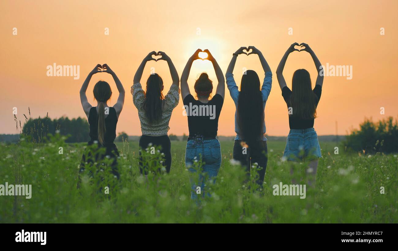 Five girls make a heart shape from their hands at sunset Stock Photo ...